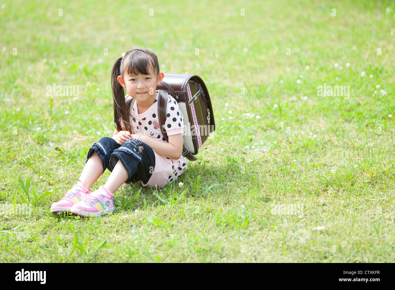 A girl sitting on grass Stock Photo - Alamy