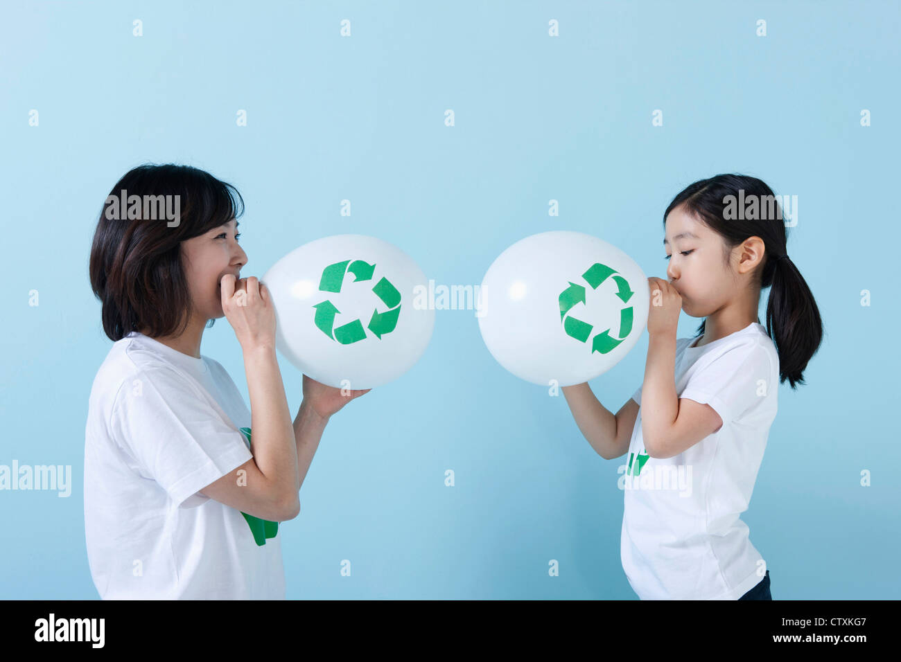 A mother and daughter blowing recycling balloons Stock Photo - Alamy