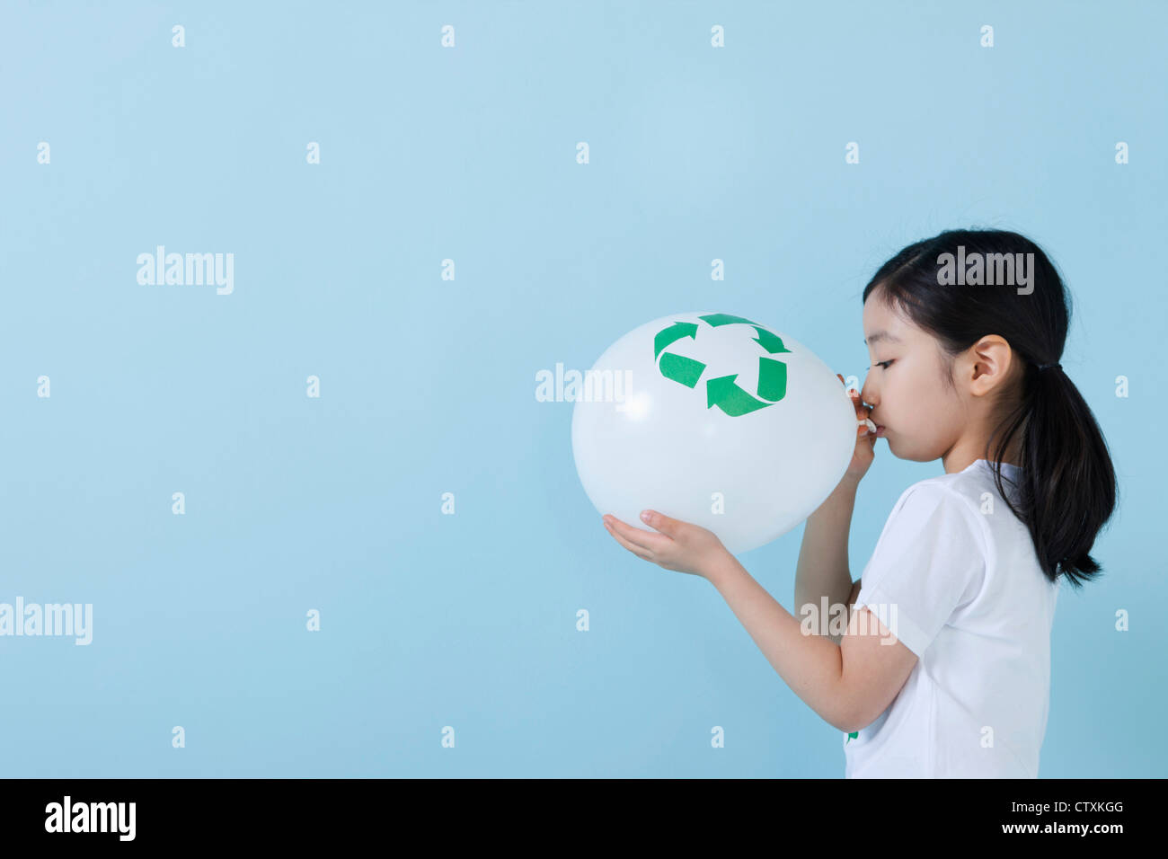 A girl blowing a recycling balloon Stock Photo - Alamy