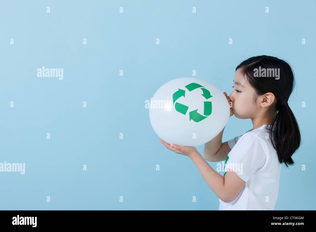 A girl blowing a recycling balloon Stock Photo - Alamy