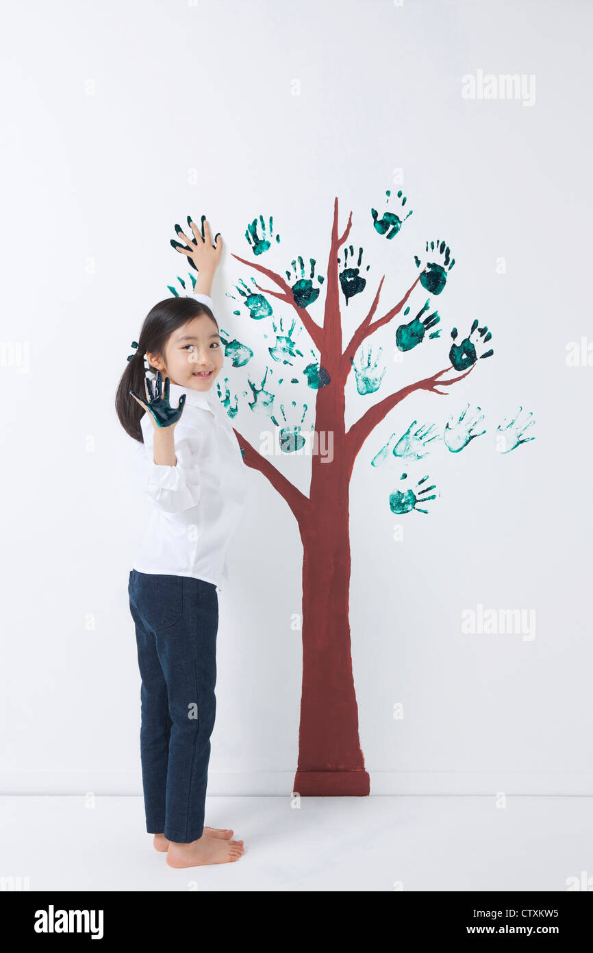 A girl painting the tree with hands Stock Photo - Alamy