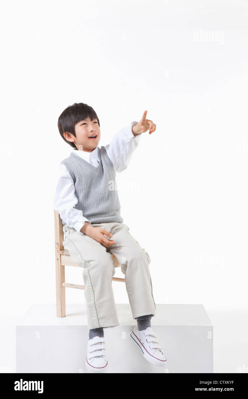 A boy pointing to the sky on the chair Stock Photo - Alamy