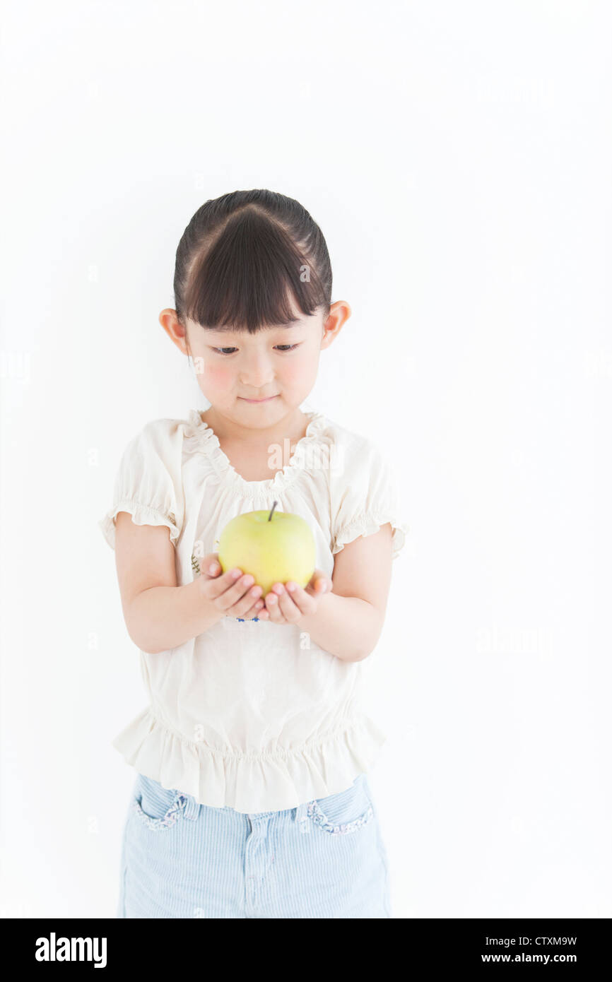 A girl holding an apple Stock Photo - Alamy