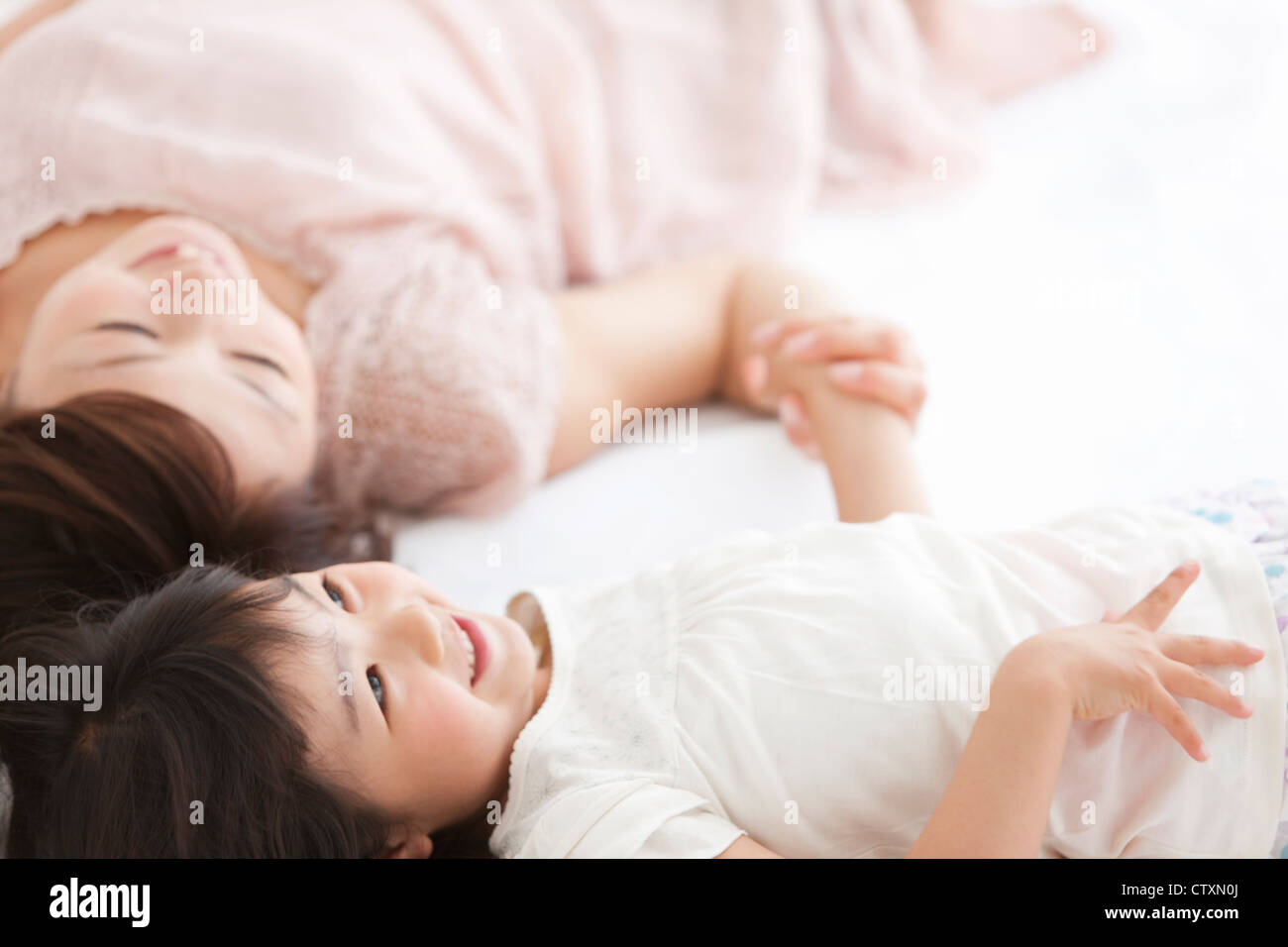 Family Lay On Back, Holding Hands Stock Photo - Alamy