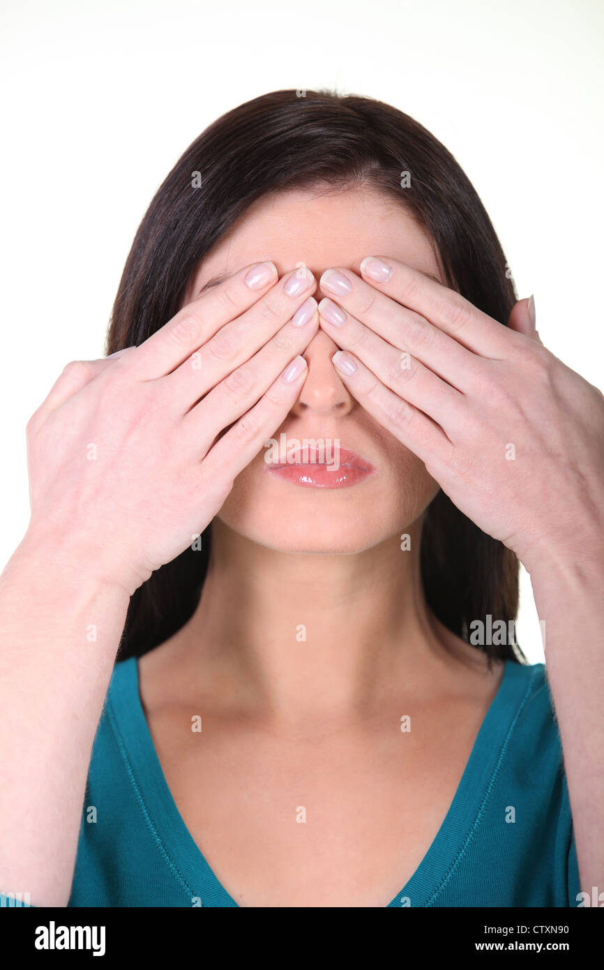 Brunette woman with her hands over her eyes Stock Photo - Alamy