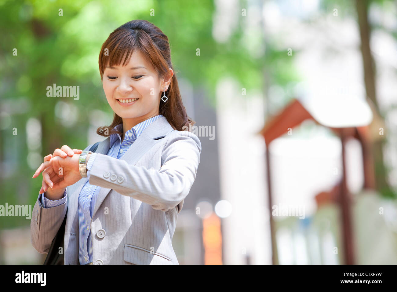 Businesswoman looking at watch Stock Photo - Alamy
