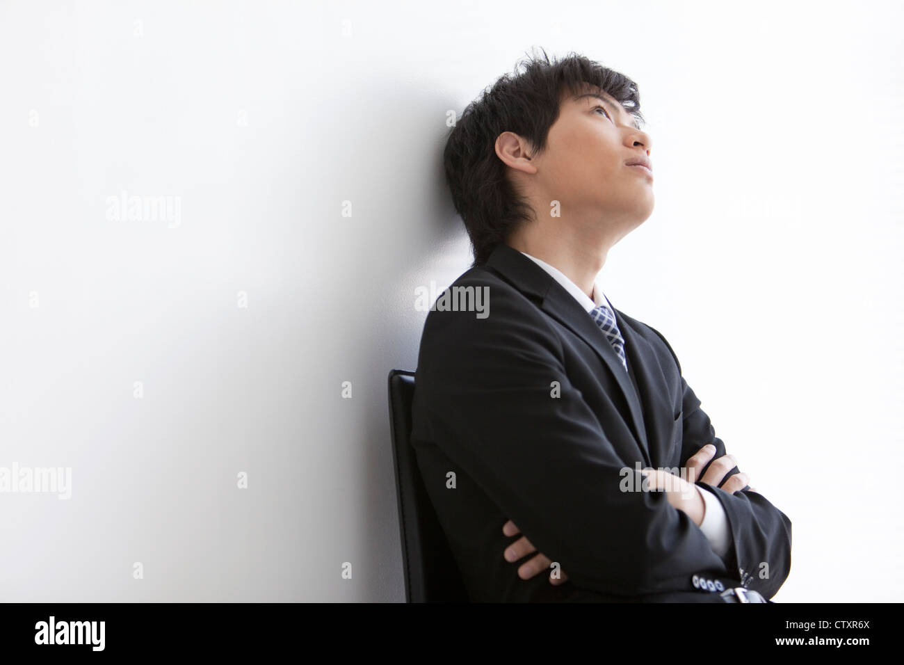 Businessman thinking with his arms crossed Stock Photo - Alamy