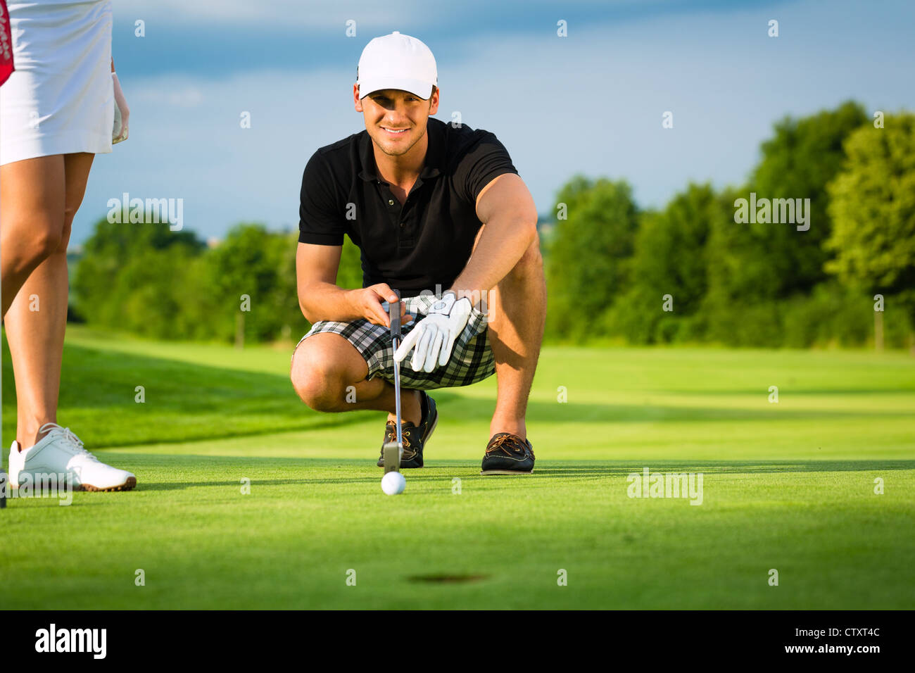 Young golf player on course putting, he aiming for his put shot Stock ...