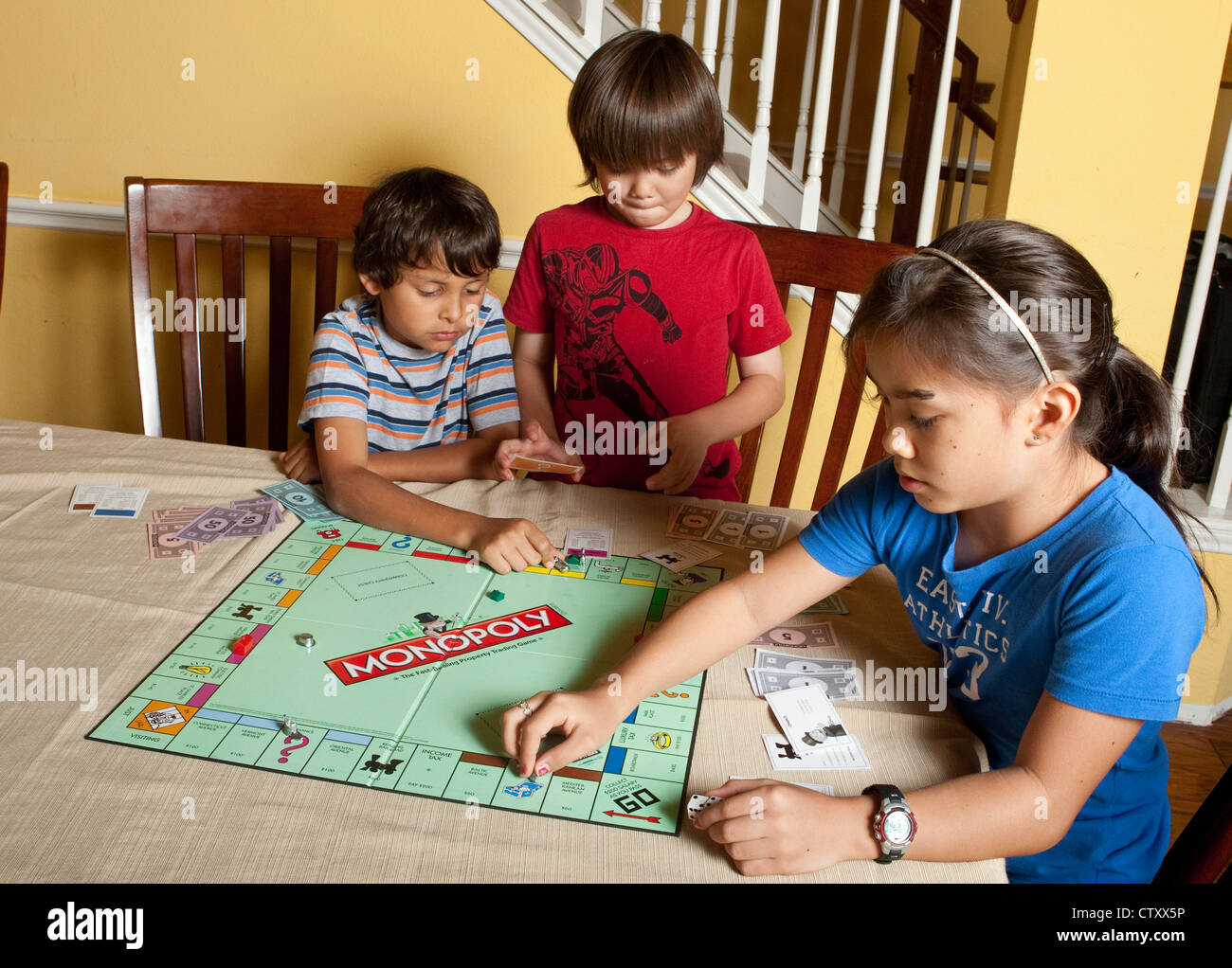 Multi-ethnic group of friends Hispanic and Asian play board game ...