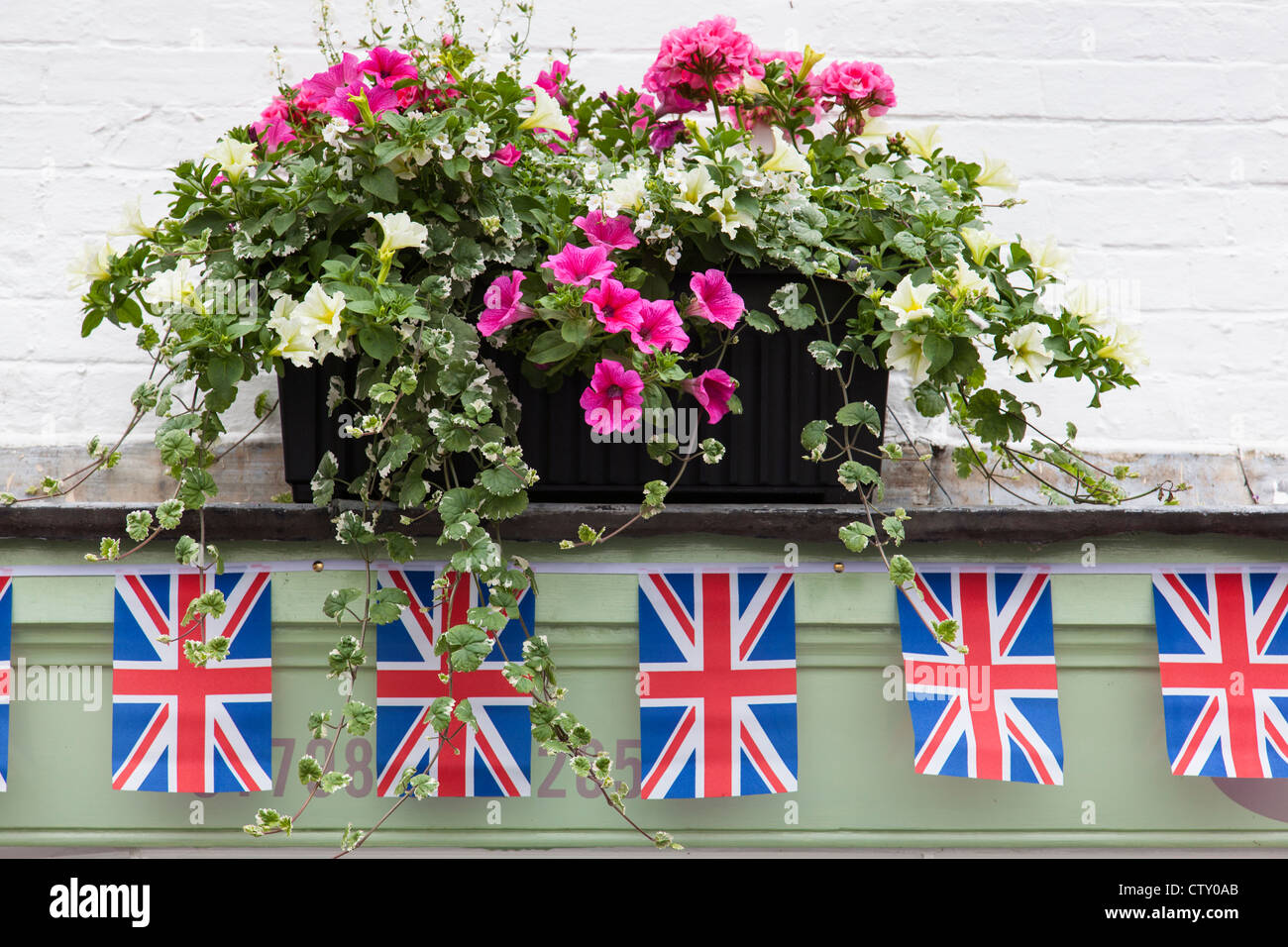 String of union flags together with a plant display decorate a building ...