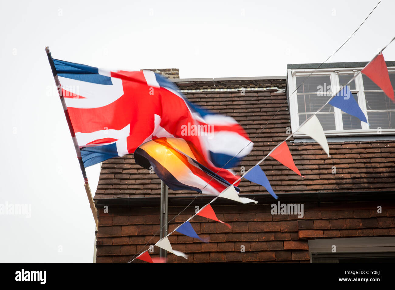 Large Union flag with a street light shining through flutters in the ...