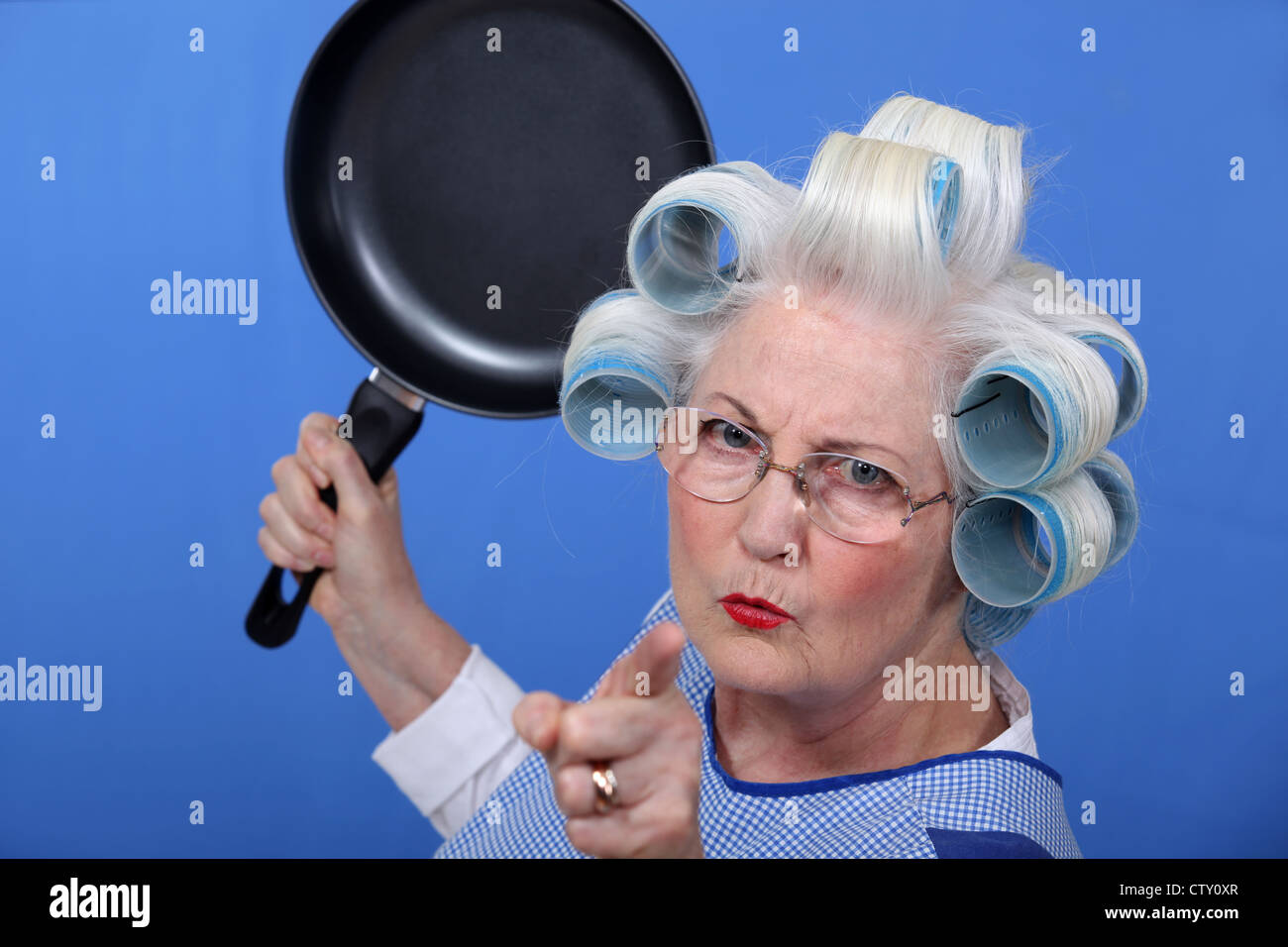 Angry old woman with a frying pan Stock Photo - Alamy