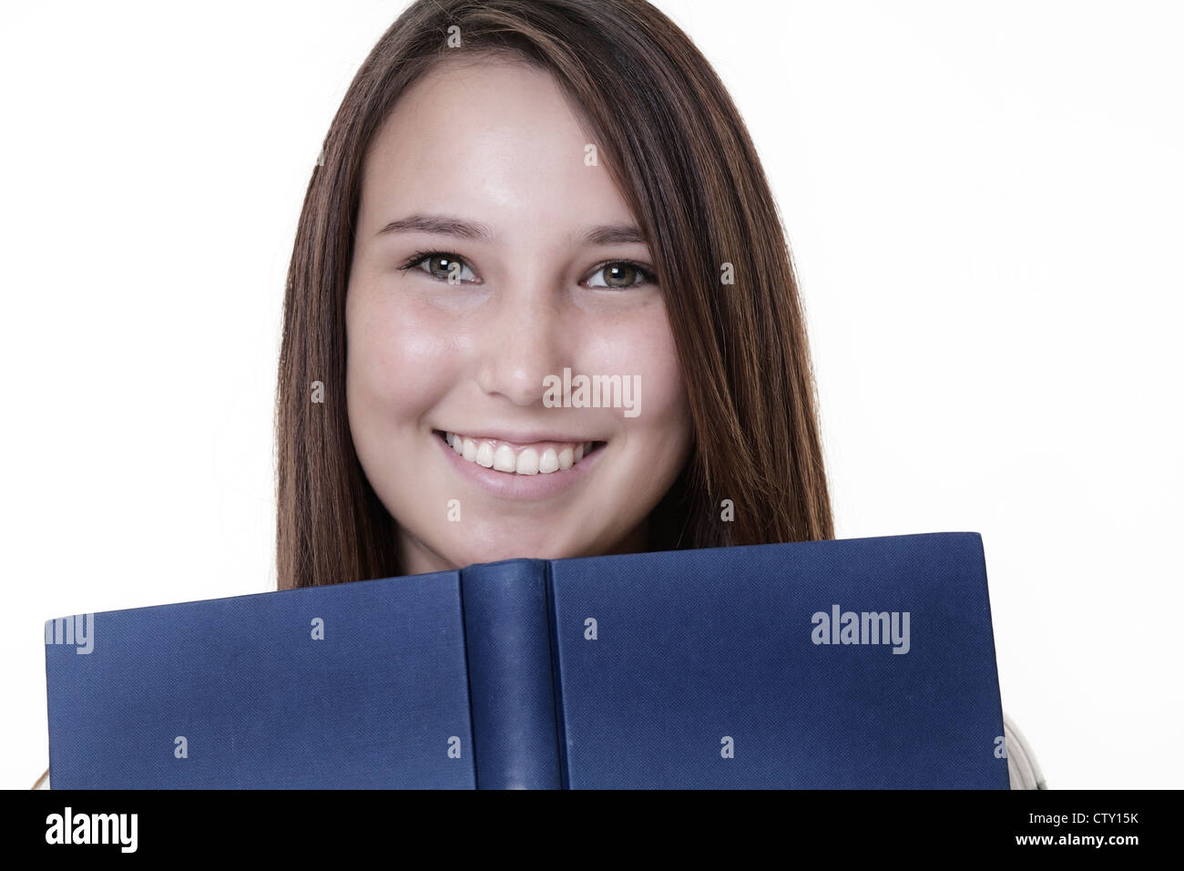 young woman peering over a hard back book Stock Photo - Alamy