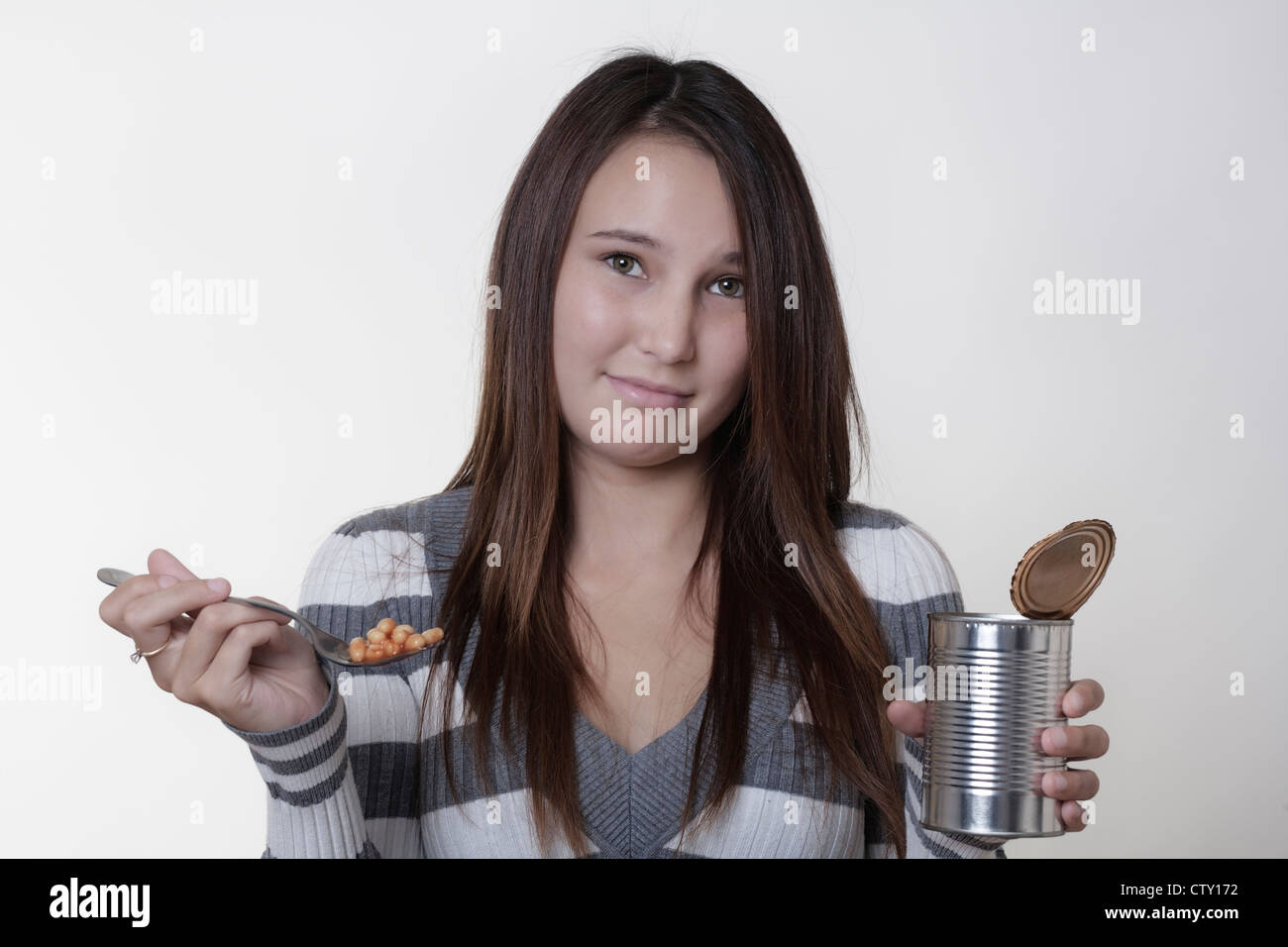 young woman eating cold bake beans from the tin Stock Photo - Alamy