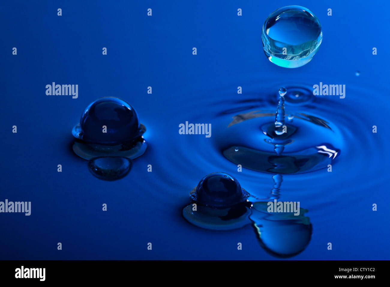 falling water drops splashing in water in blue light Stock Photo - Alamy