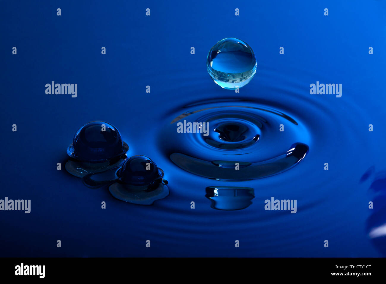 falling water drops splashing in water in blue light Stock Photo - Alamy
