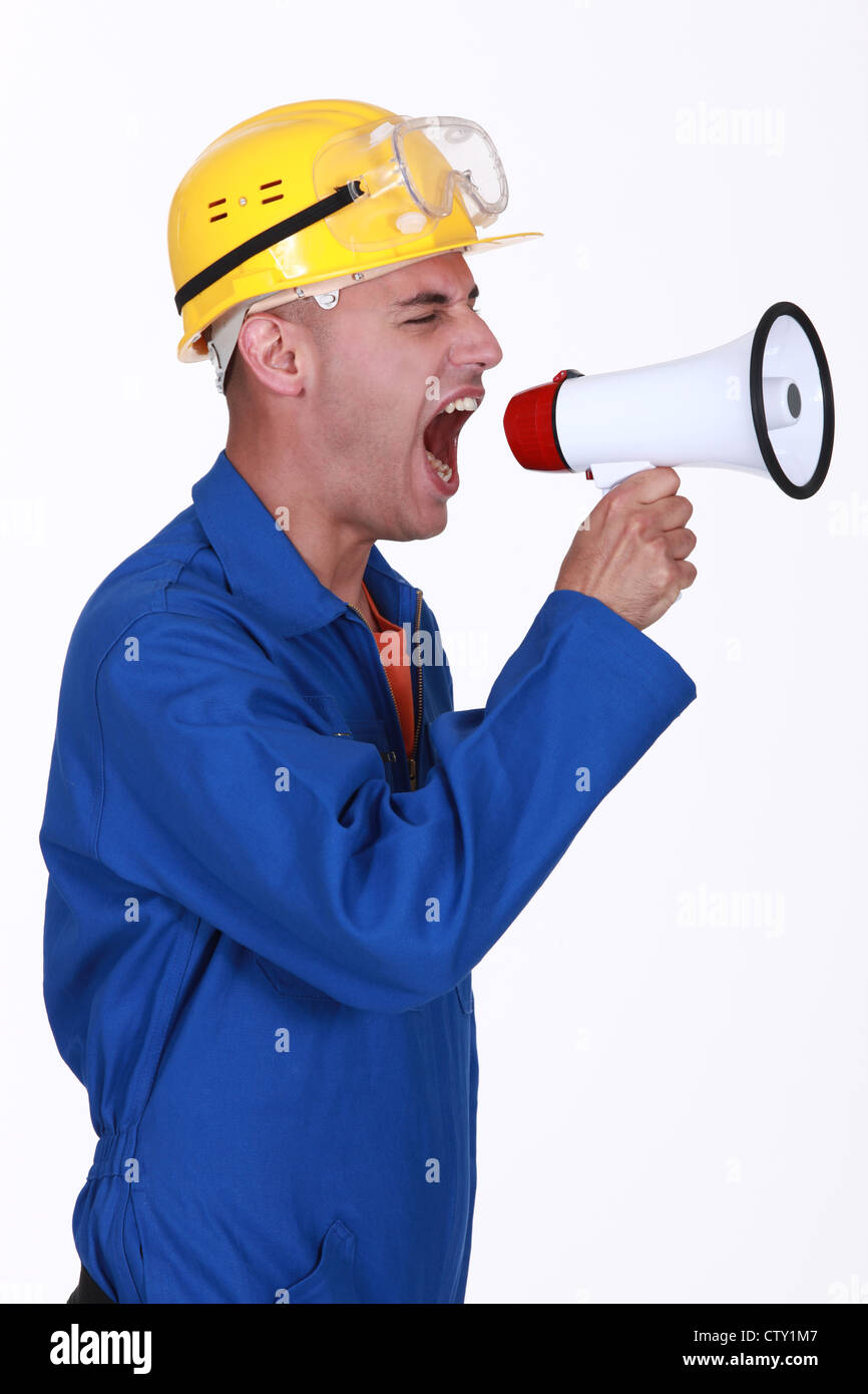 Angry builder shouting through megaphone Stock Photo - Alamy