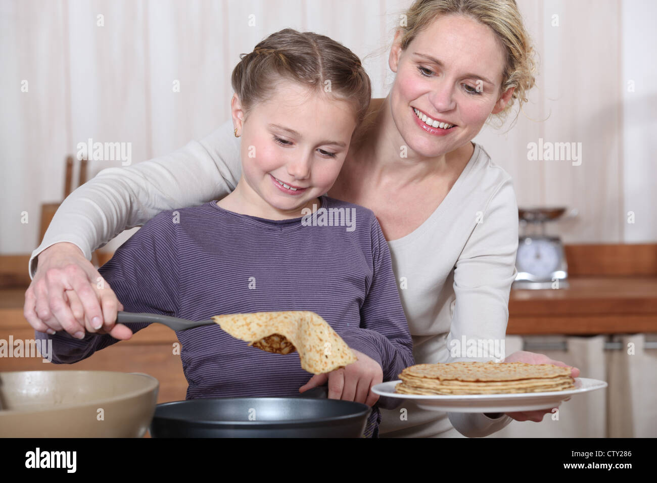 Mother and daughter making crepes together Stock Photo - Alamy
