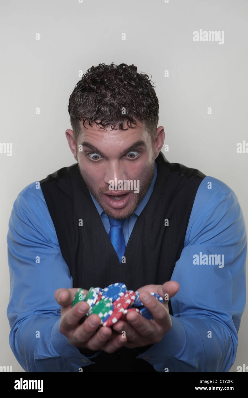 handsome man holding a lot of poker chips in two hands looking very ...