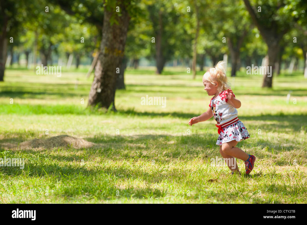 Female toddler crying while running in park Stock Photo - Alamy