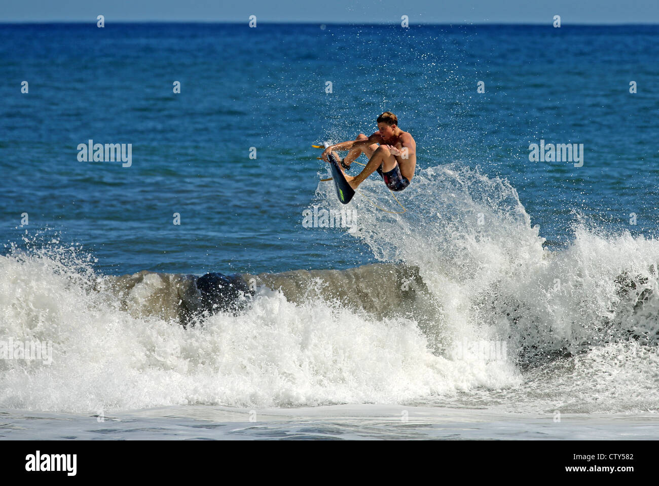 Australian surfer gets high in the air while surfing a beach break in ...