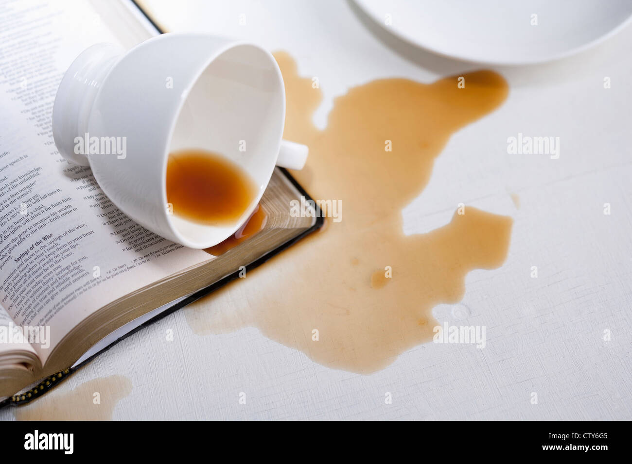 A fallen cup of coffee on the book Stock Photo - Alamy