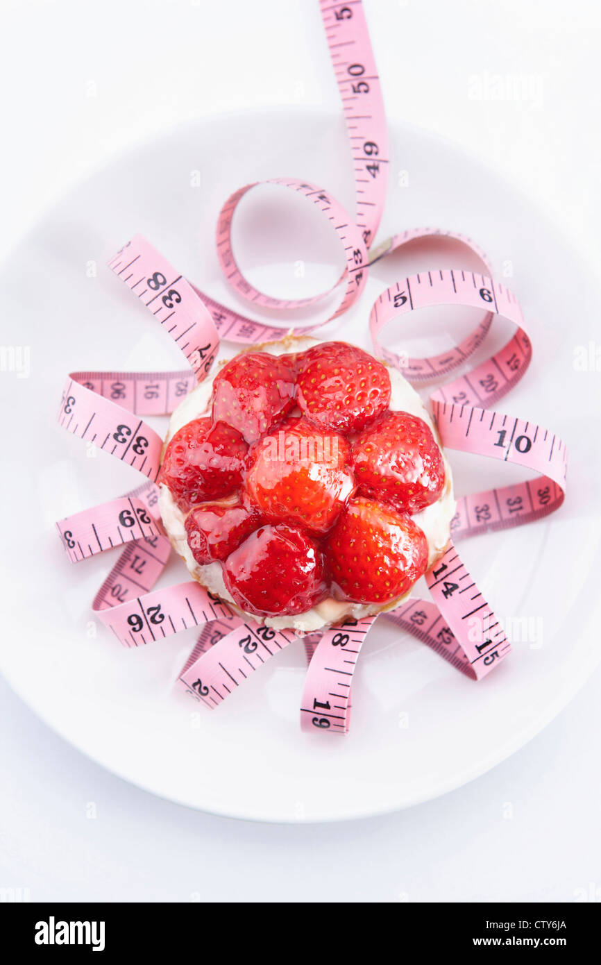 A measuring tape and cake on the dish Stock Photo - Alamy