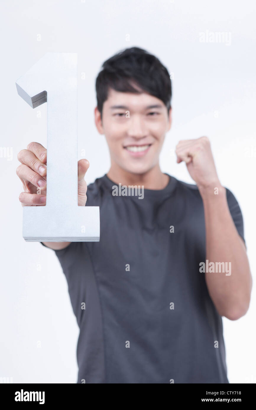 A cheerful man holding the number one Stock Photo - Alamy