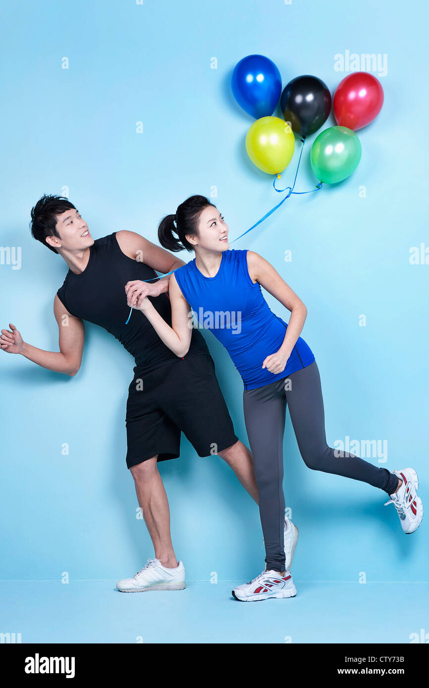 A jogging man and woman with colorful balloons Stock Photo - Alamy