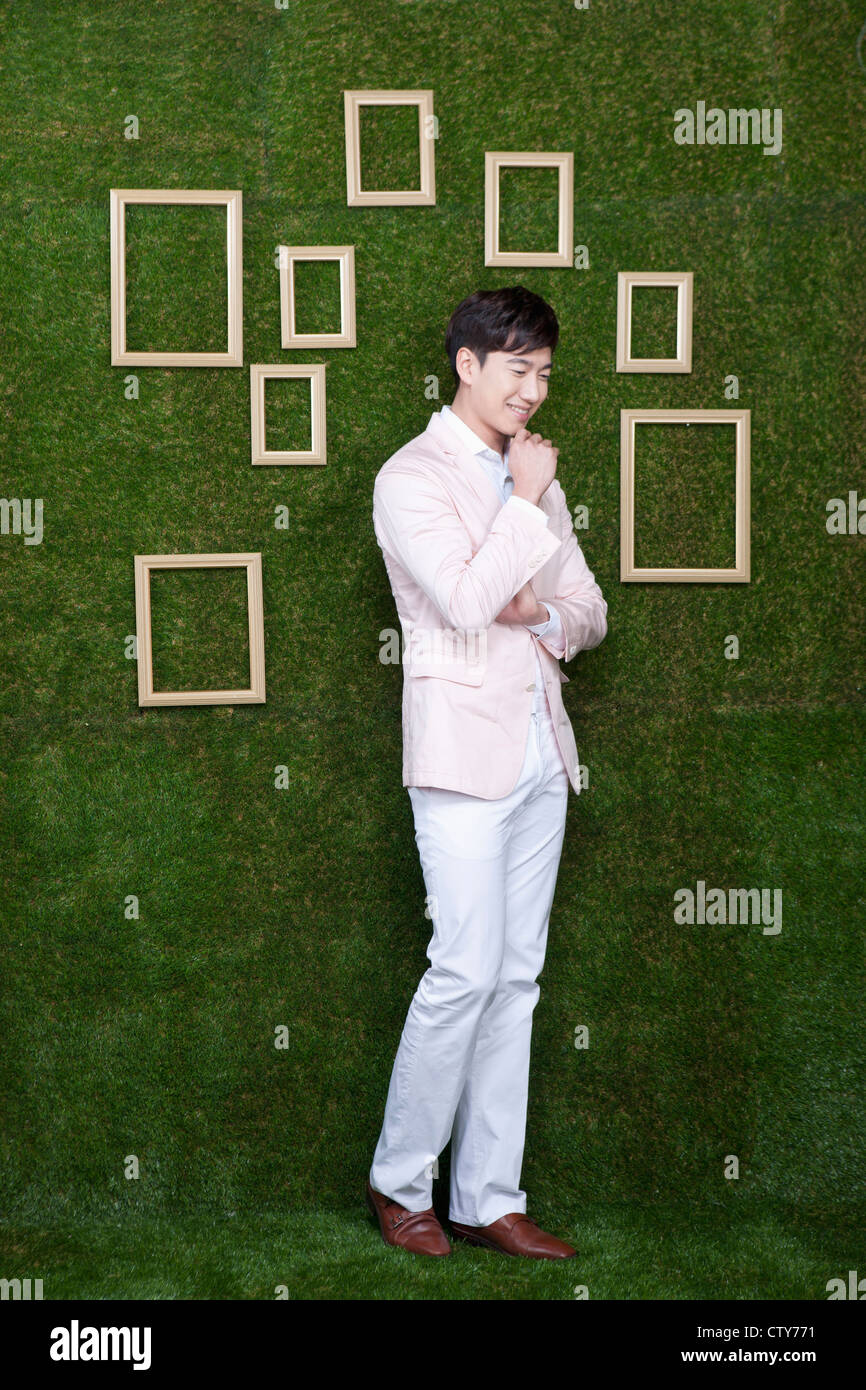 A man and wooden frames on the green wall Stock Photo - Alamy