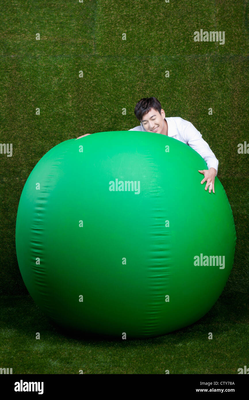 A man hugging a green ball Stock Photo - Alamy