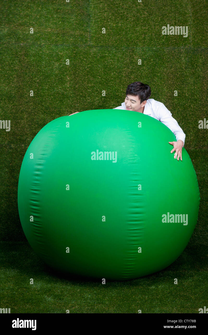 A man hugging a green ball Stock Photo - Alamy