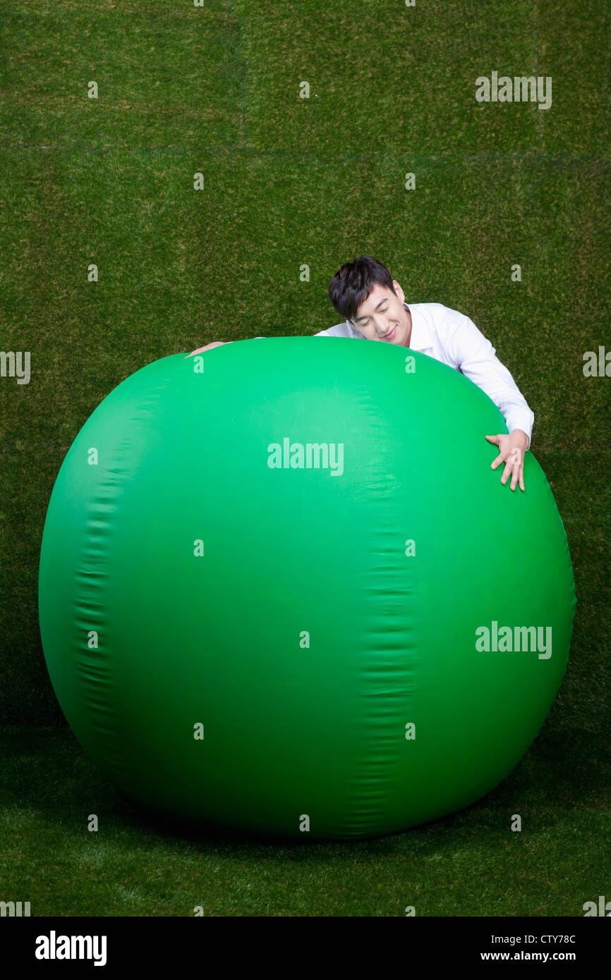 A man hugging a green ball Stock Photo - Alamy
