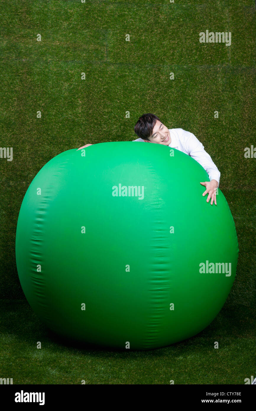 A man hugging a green ball Stock Photo - Alamy