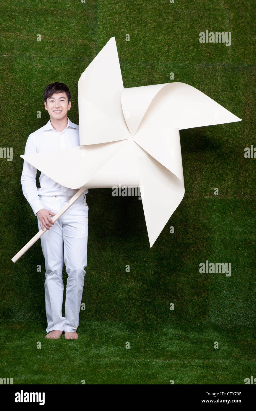 A man holding a white pinwheel Stock Photo - Alamy