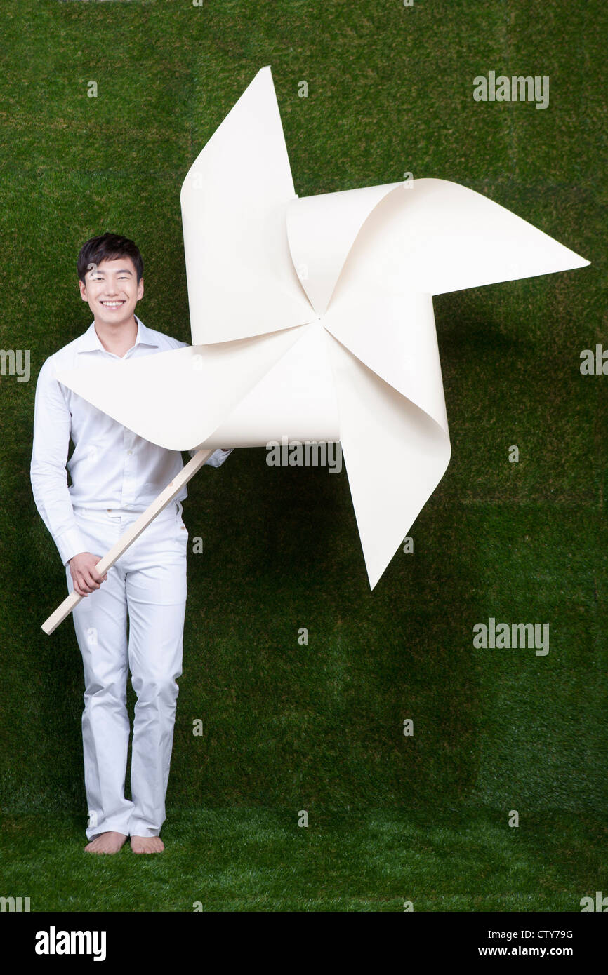 A man holding a white pinwheel Stock Photo - Alamy