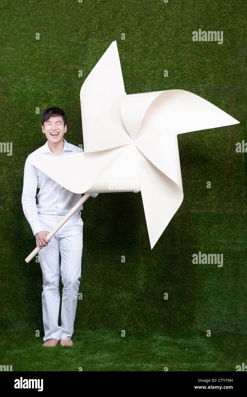 A man holding a white pinwheel Stock Photo - Alamy