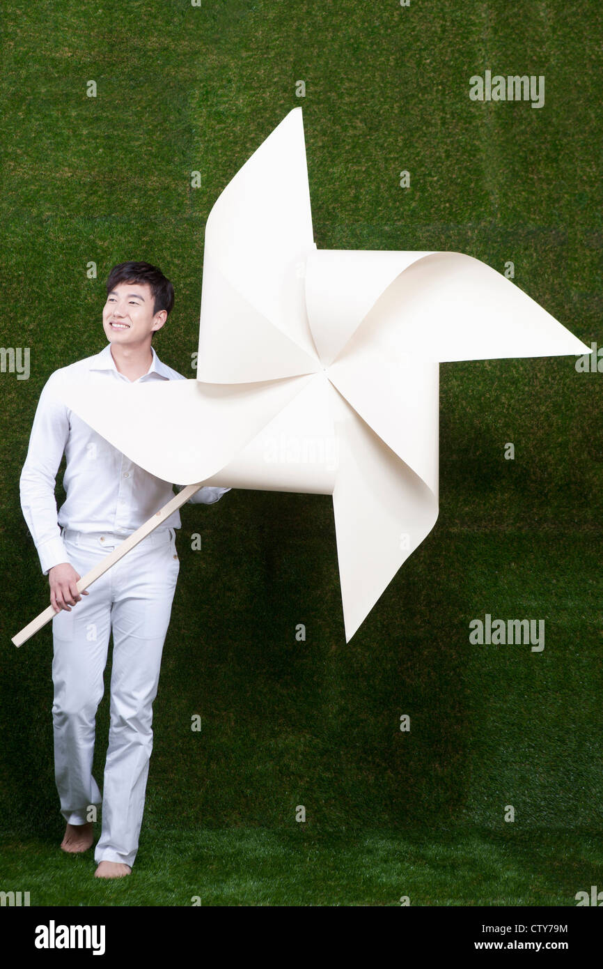 A man holding a white pinwheel Stock Photo - Alamy