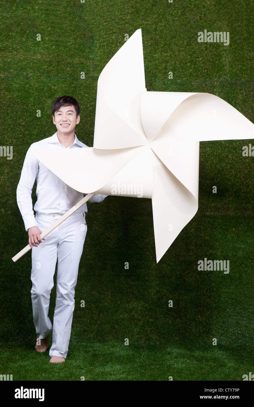 A man holding a white pinwheel Stock Photo - Alamy