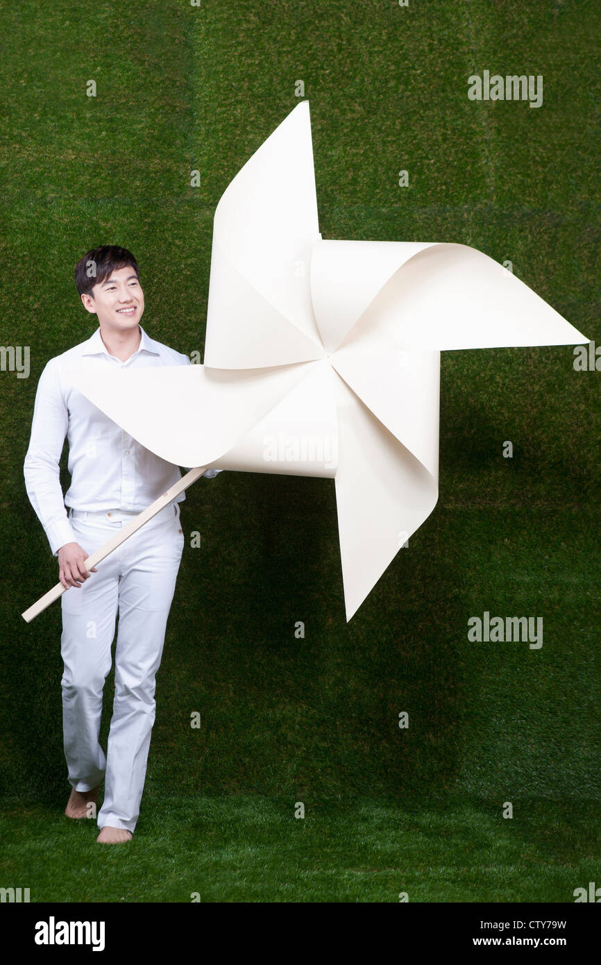 A man holding a white pinwheel Stock Photo - Alamy