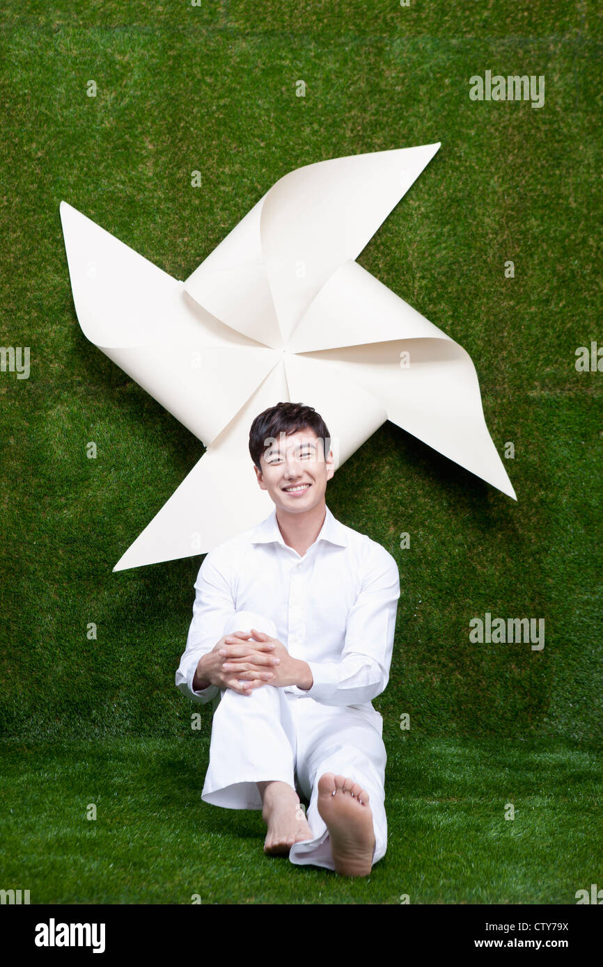A man sitting with a white pinwheel Stock Photo - Alamy