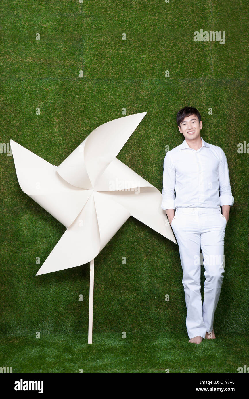 A man sitting with a white pinwheel Stock Photo - Alamy