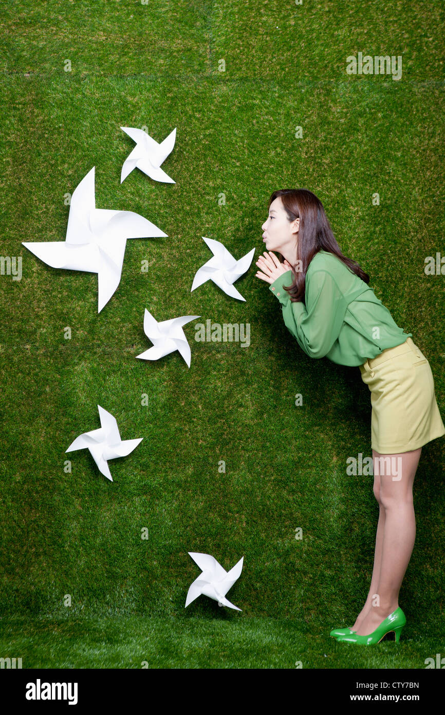 A woman blowing the white pinwheels Stock Photo - Alamy