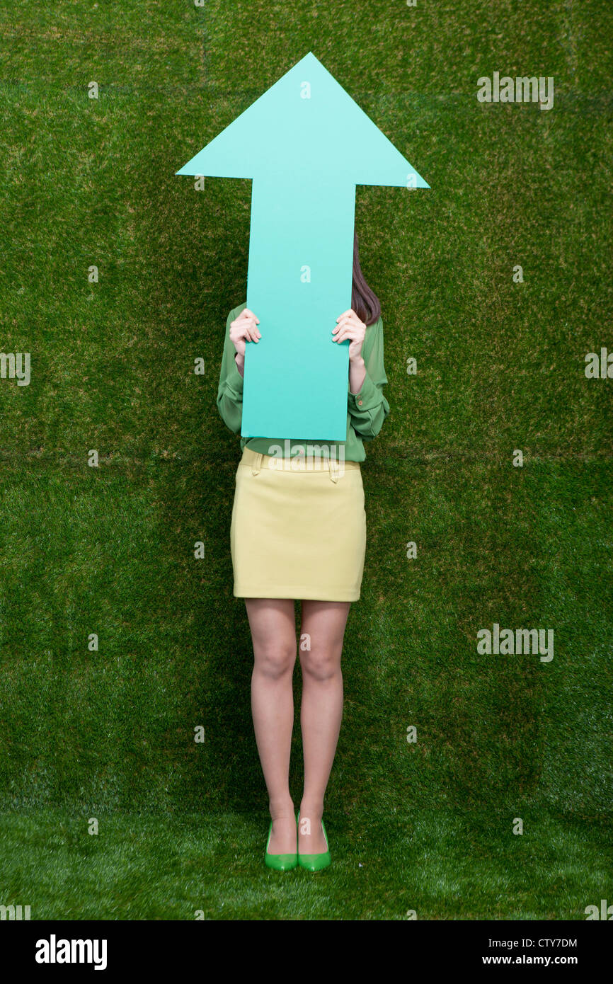 A woman behind a green arrow Stock Photo - Alamy