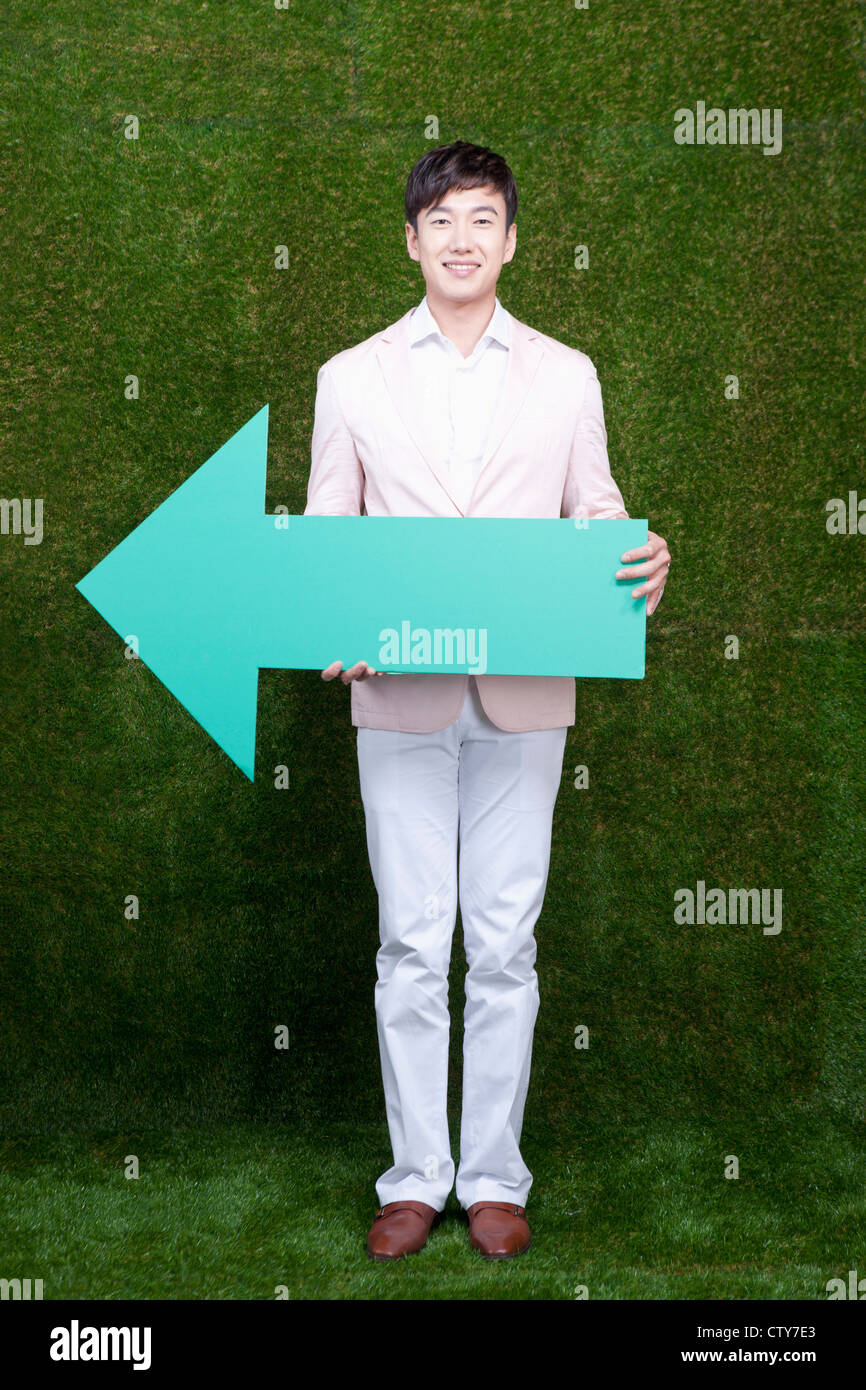 A man standing with a green arrow Stock Photo - Alamy