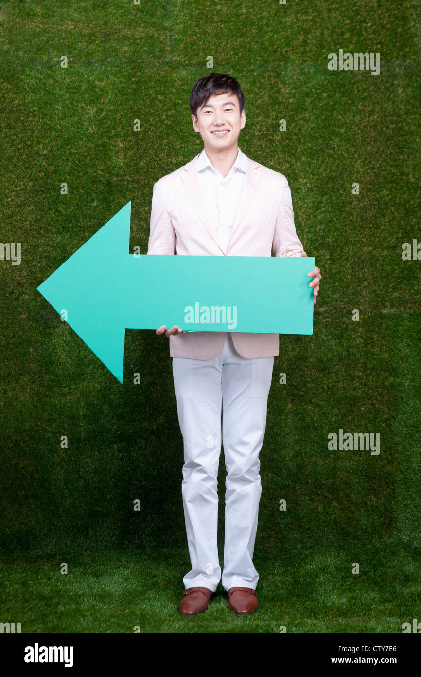 A man standing with a green arrow Stock Photo - Alamy