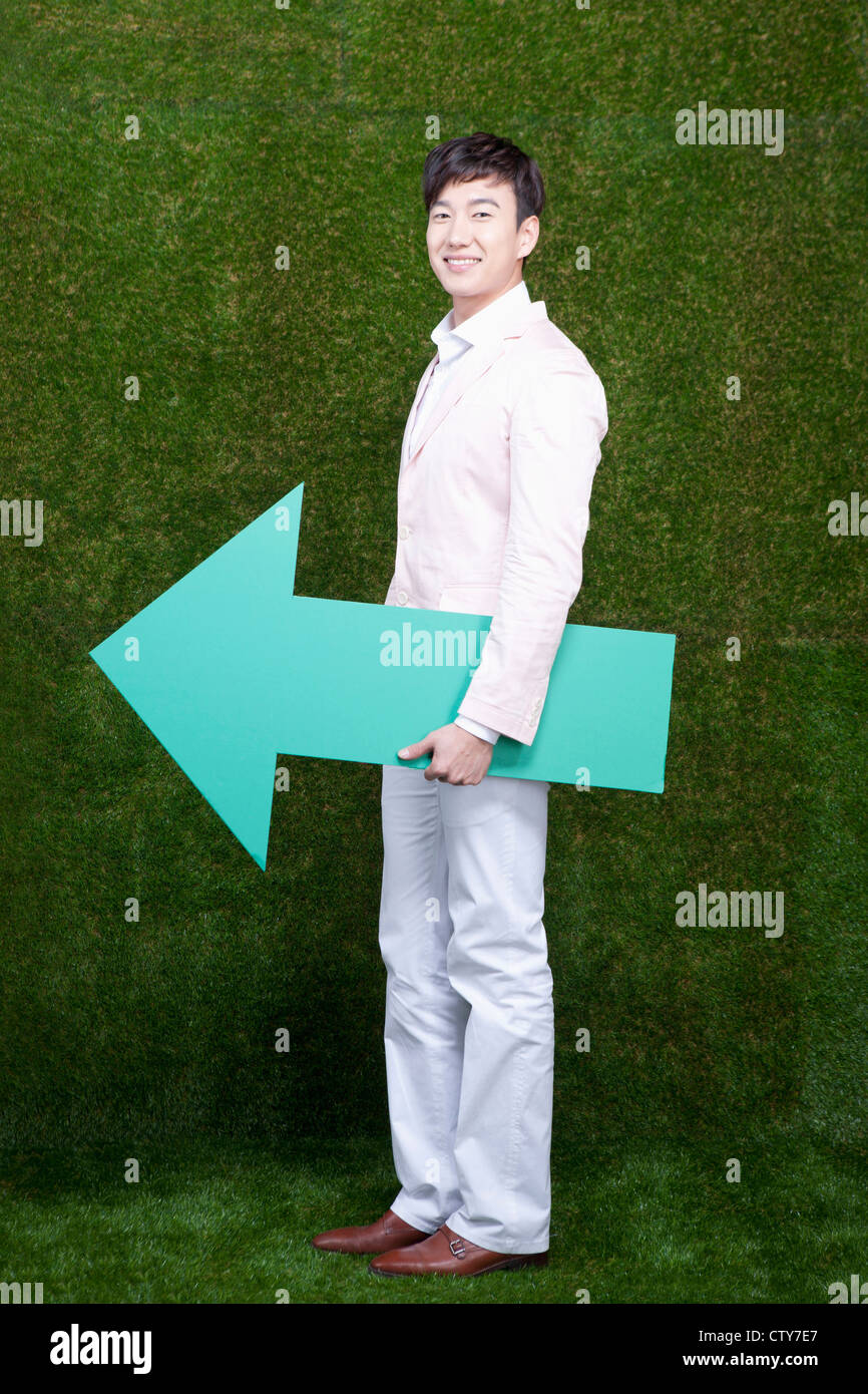 A man standing with a green arrow Stock Photo - Alamy