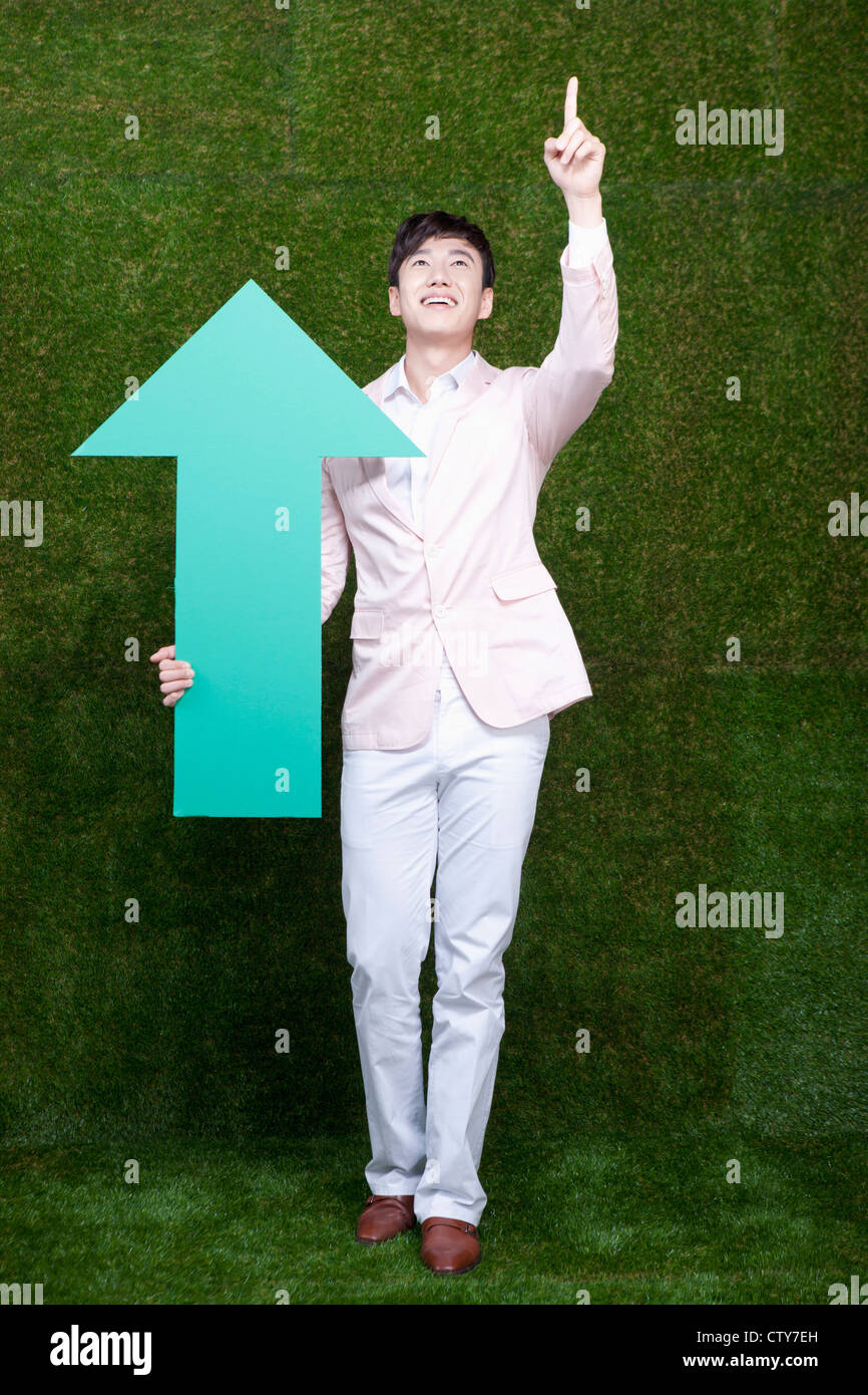 A man pointing at the sky with a green arrow Stock Photo - Alamy