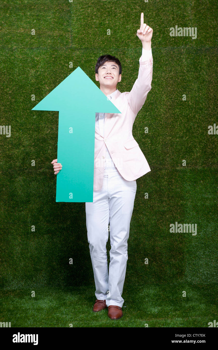 A man pointing at the sky with a green arrow Stock Photo - Alamy