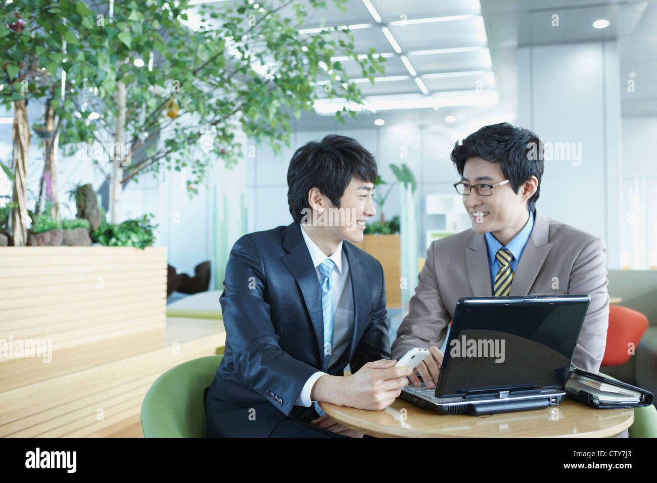 Businessmen having a talk in the lounge Stock Photo - Alamy